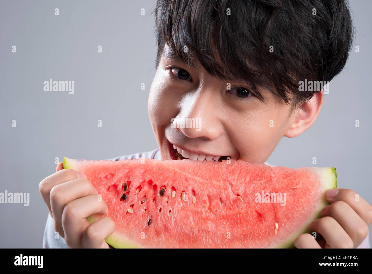 Young man eating watermelon Stock Photo - Alamy