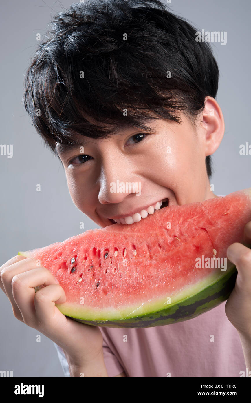 Young man eating watermelon Stock Photo - Alamy