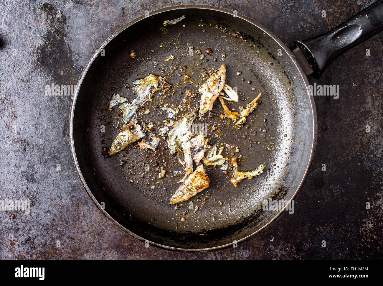 Frying pan with the leftovers of a fried fish Stock Photo - Alamy