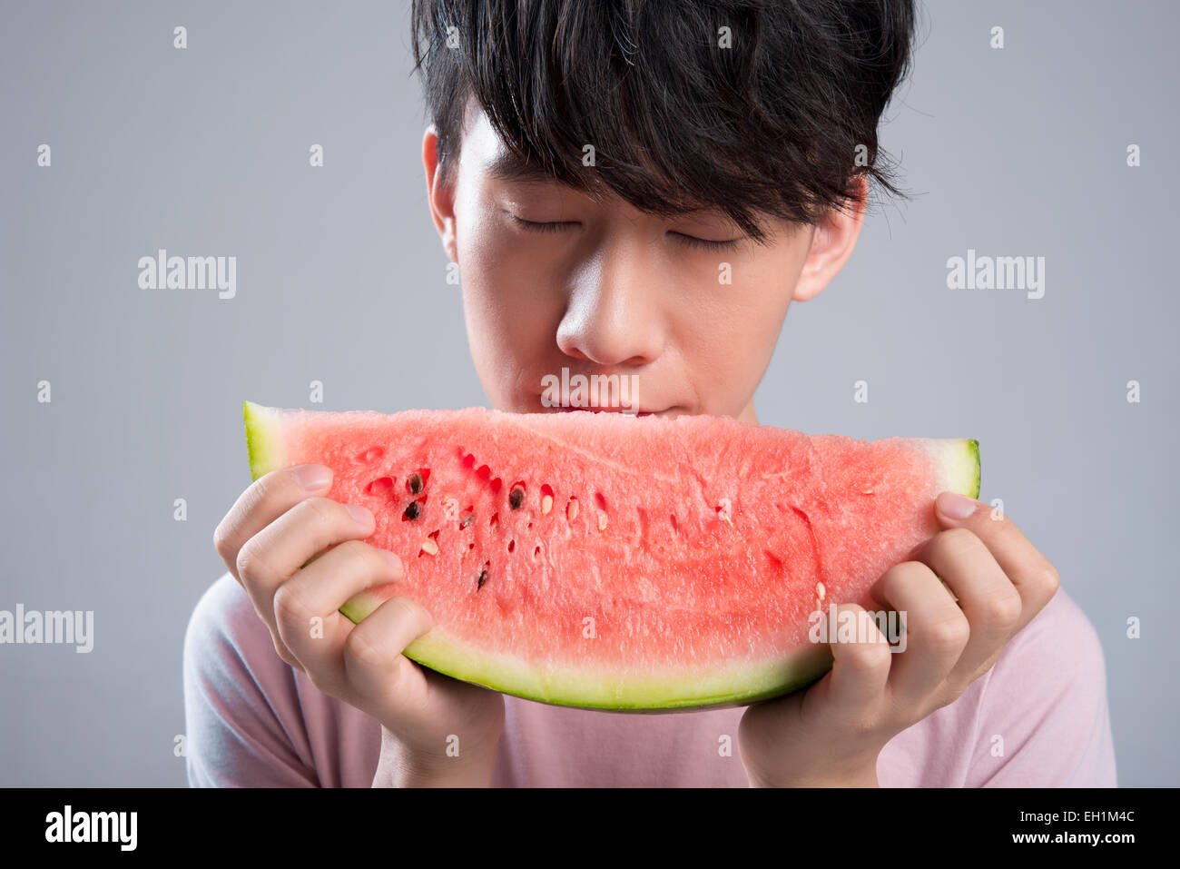 Young man eating watermelon Stock Photo - Alamy
