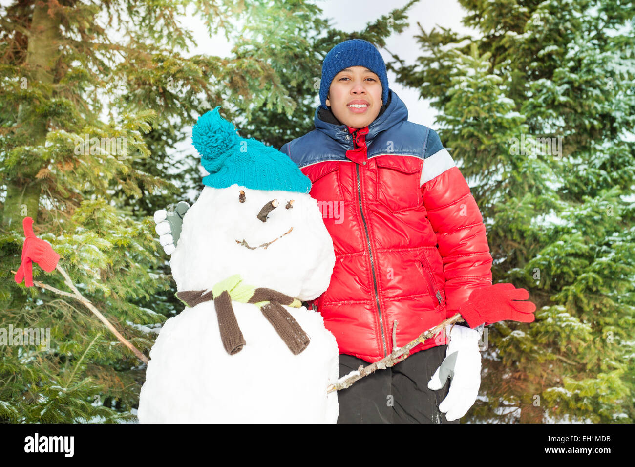 Arabian boy standing near snowman in winter Stock Photo - Alamy