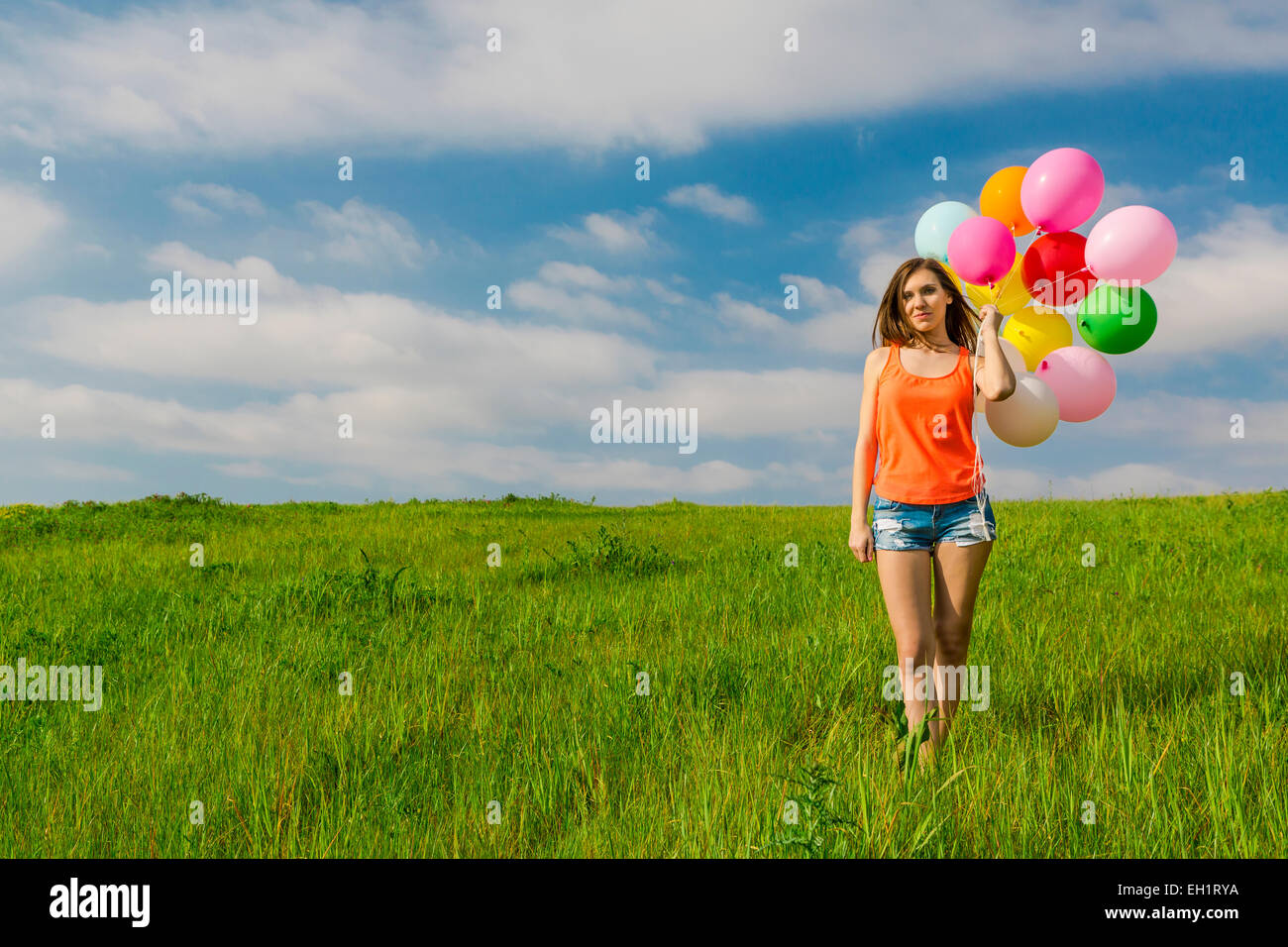 Young beautiful woman having fun with balloons on a green meadow Stock ...