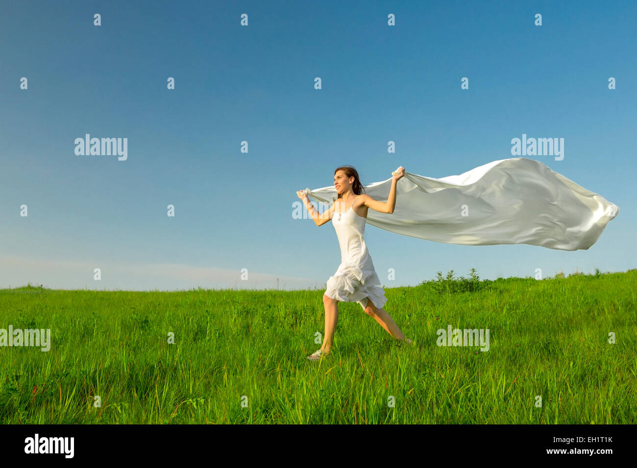 Young beautiful woman running while holding a white tissue Stock Photo ...