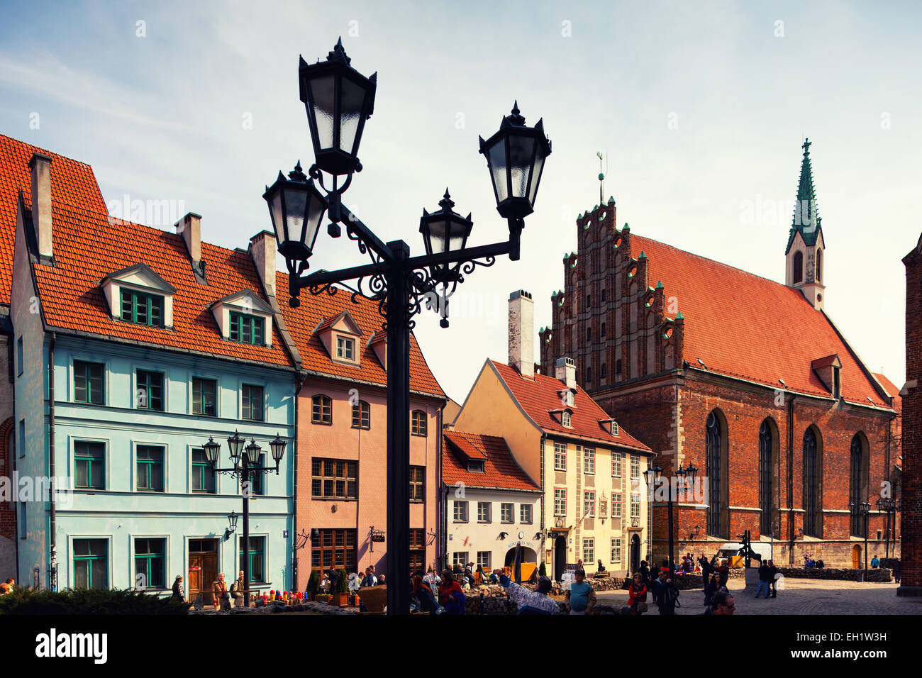 Old houses with red roofs and narrow streets of Riga with tourists on a ...