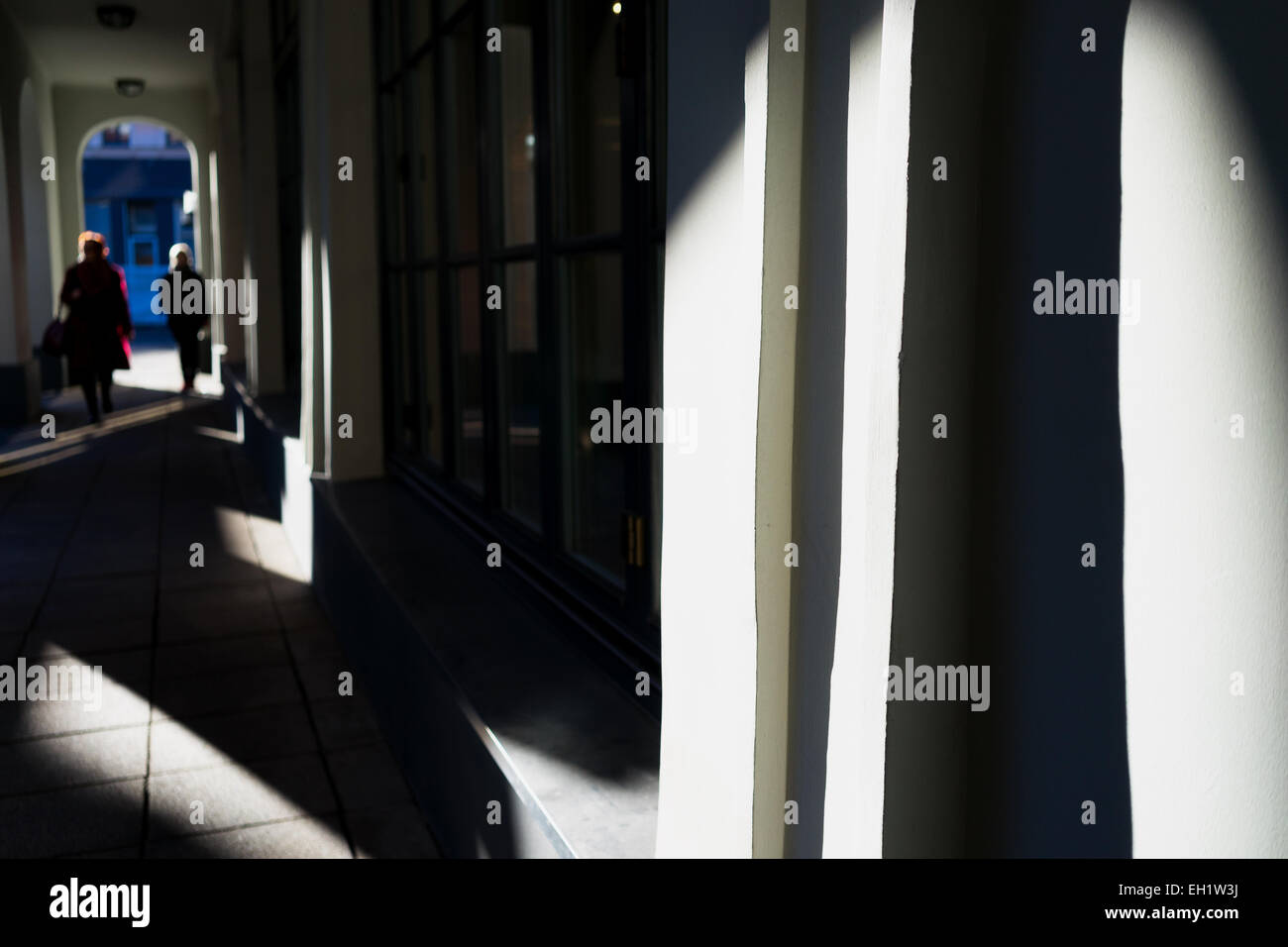 People walk through the city past the windows and walls with ...