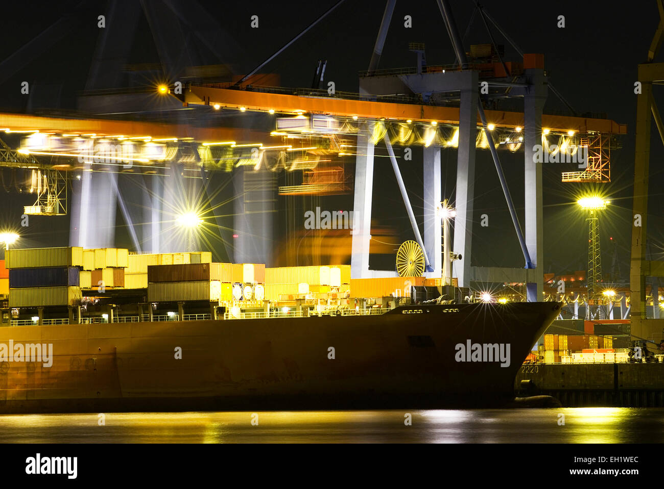 Large container ship in a busy dock at night Stock Photo - Alamy