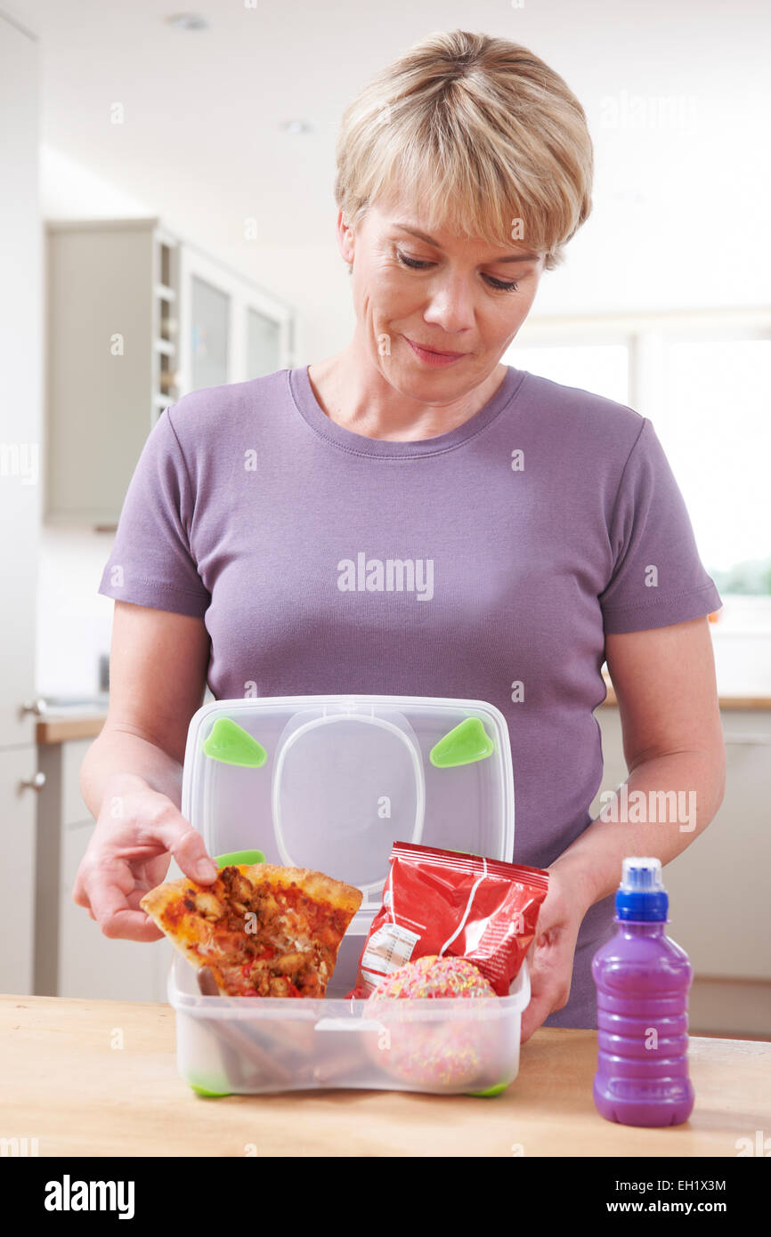 Woman Preparing Unhealthy Lunchbox In Kitchen Stock Photo - Alamy