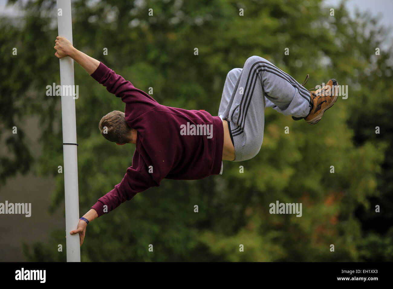 Free runner performing the human flag on a street lamp on Aberystwyth ...