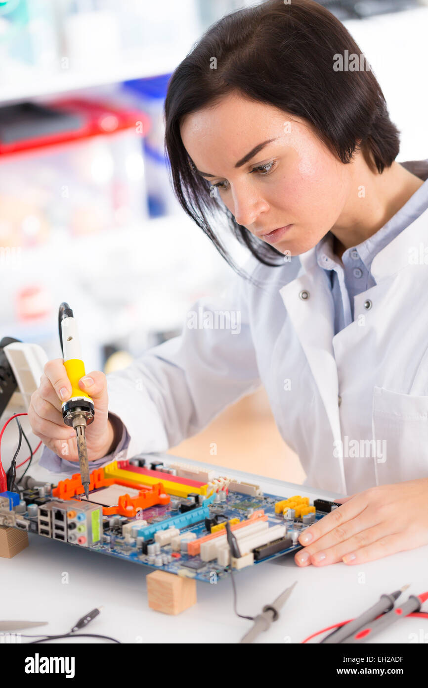 Woman with a tester and a printed circuit board Stock Photo - Alamy