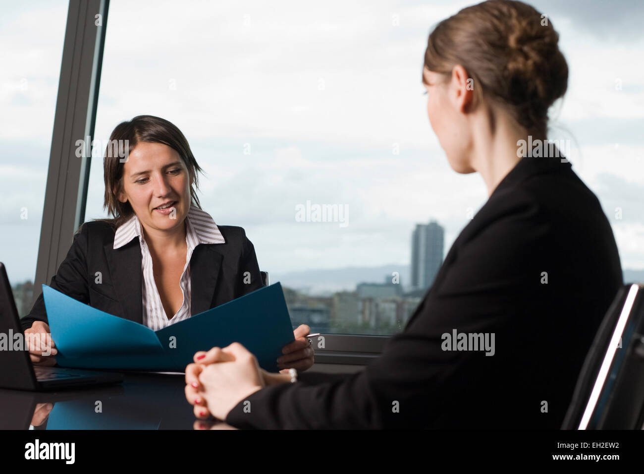 Two persons sitting at a table in office during job interview Stock ...