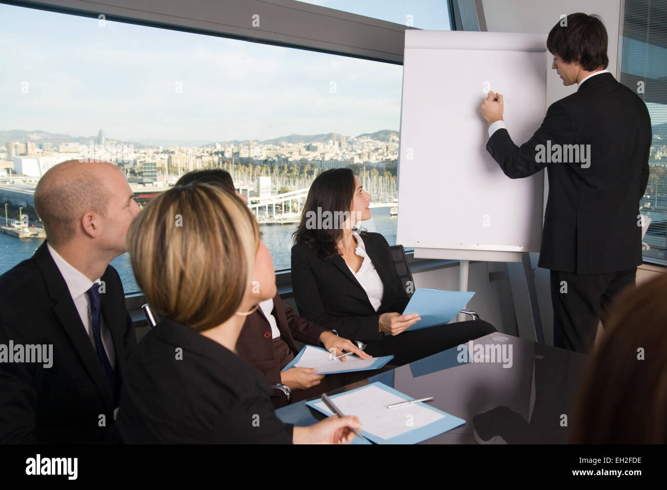 job training in a nice panorama office with a businessman writing on ...