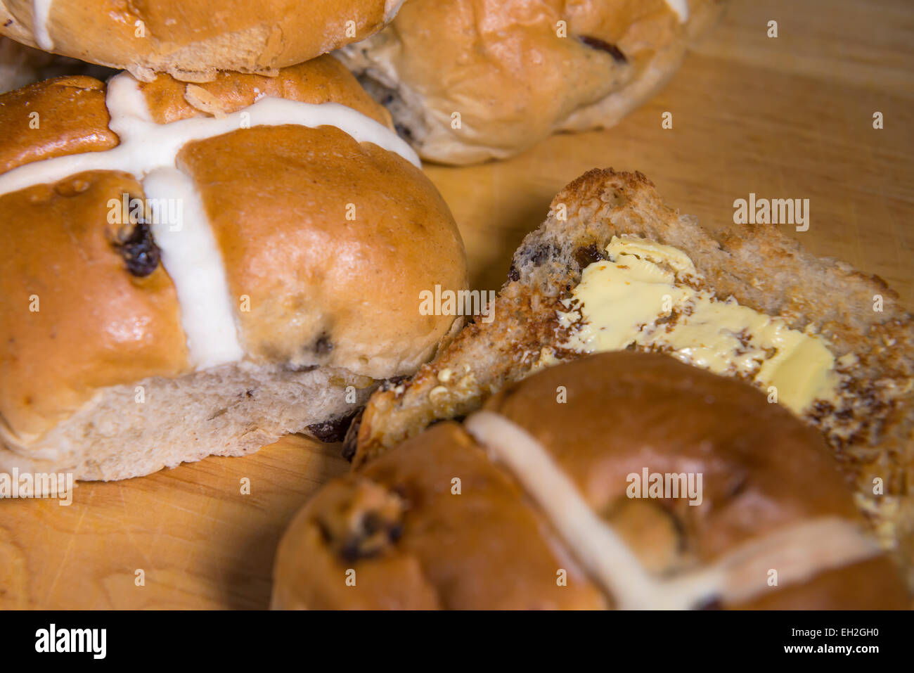 Close up of a stack of hot cross buns with a buttered bun in the ...