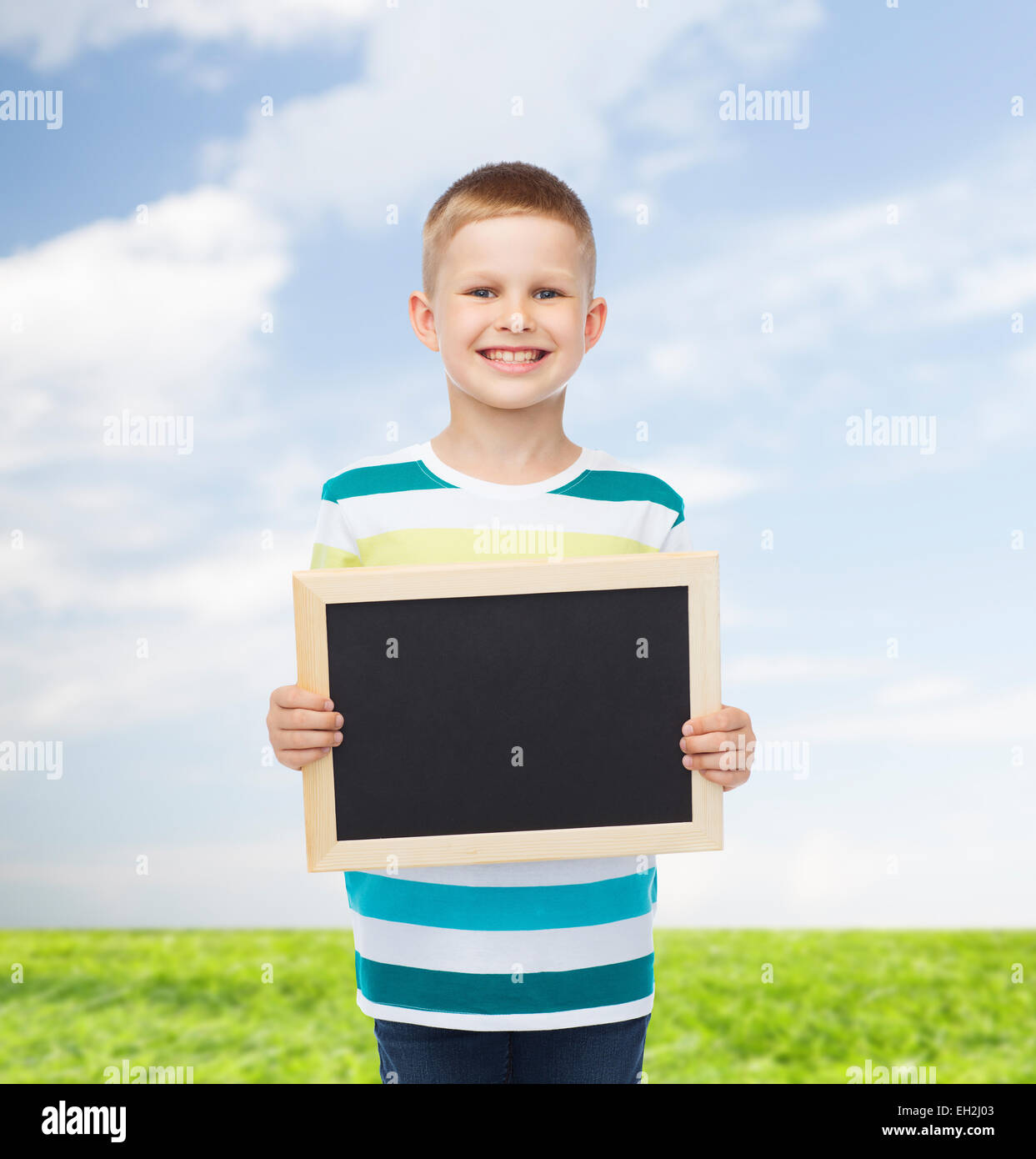 smiling little boy holding blank black chalkboard Stock Photo - Alamy