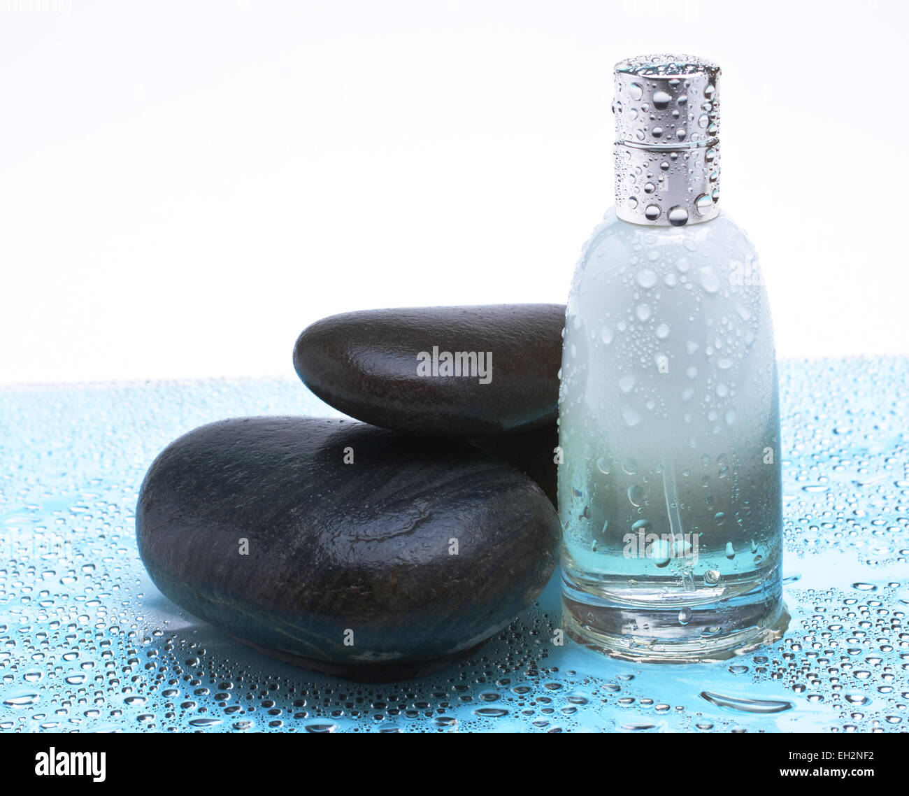 bottle of cologne wet and pebbles with drops Stock Photo - Alamy