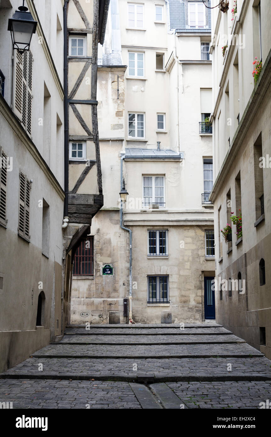 A half-timbered building juts out into a narrow, cobbled street in the ...
