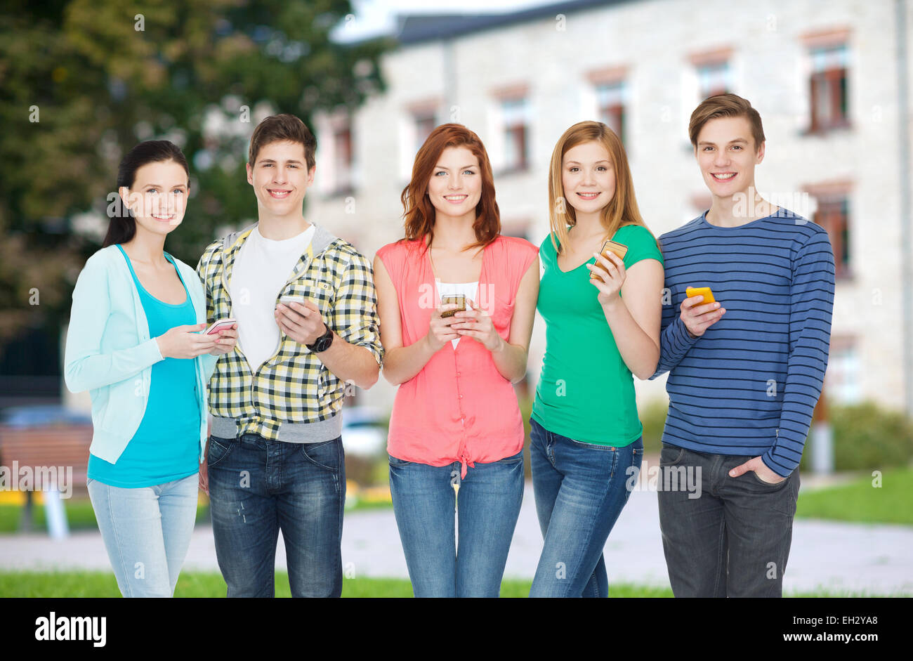 smiling students with smartphones Stock Photo - Alamy