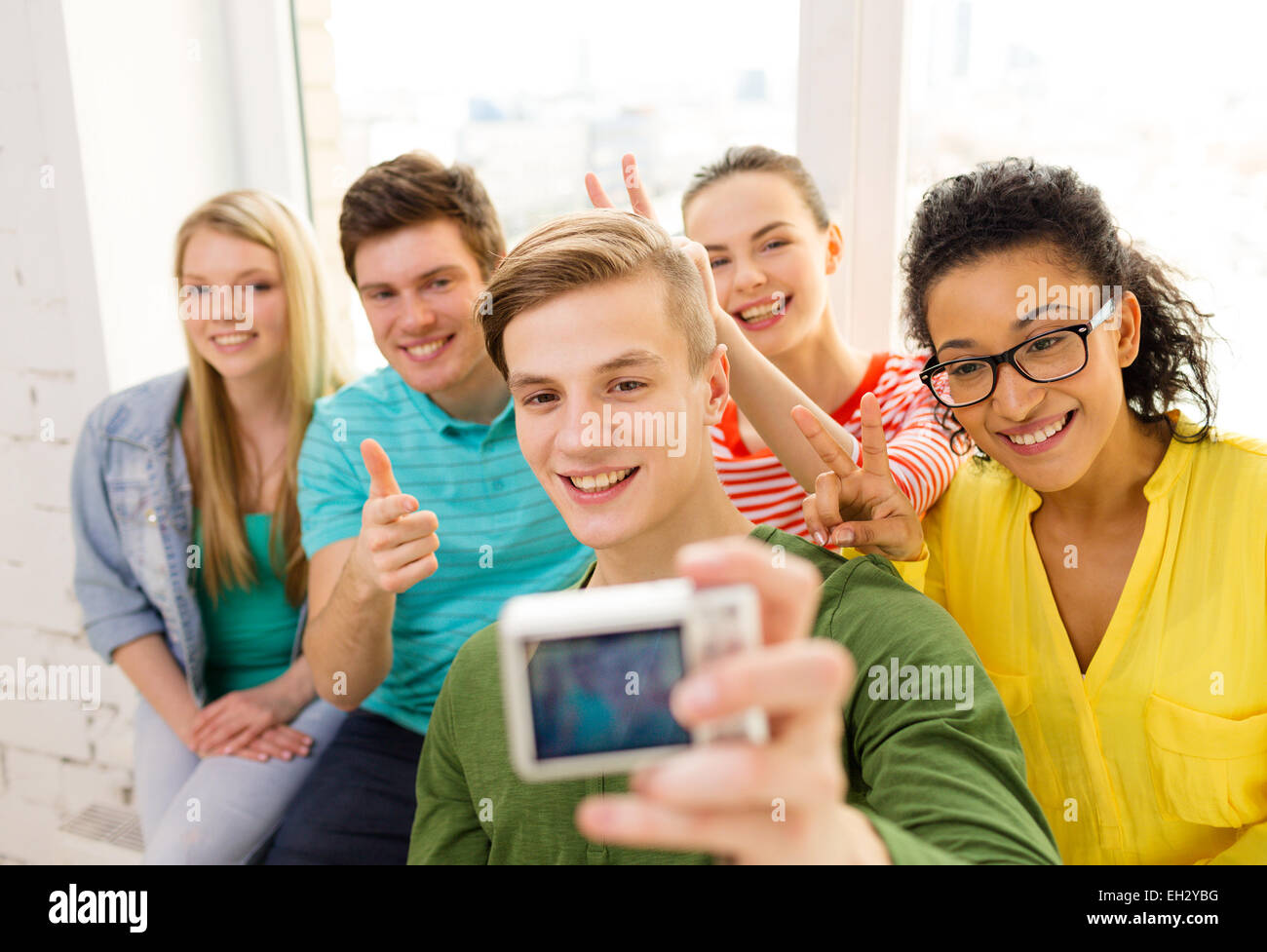 five smiling students taking picture with camera Stock Photo - Alamy