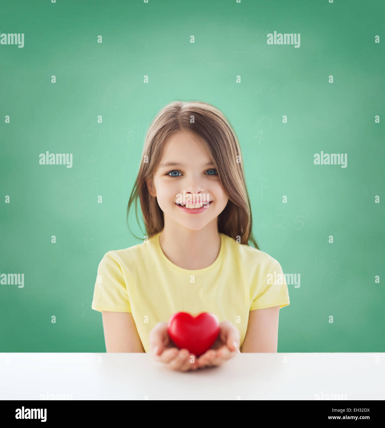 beautiful little girl sitting at table Stock Photo - Alamy