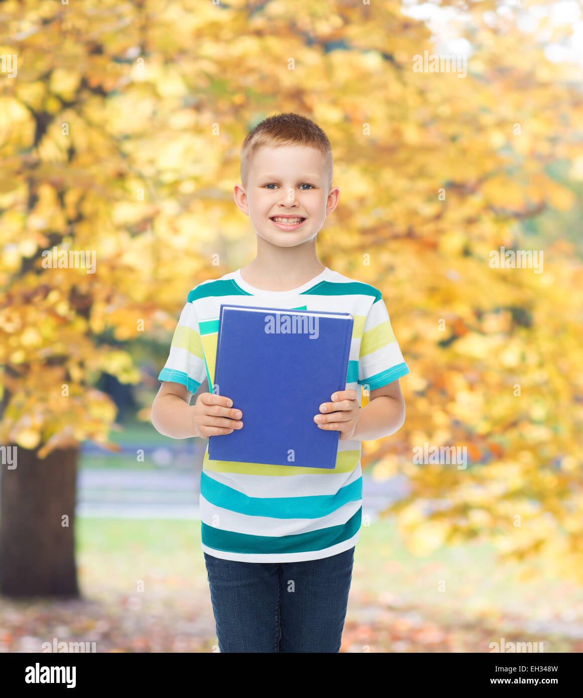 smiling little student boy with blue book Stock Photo - Alamy