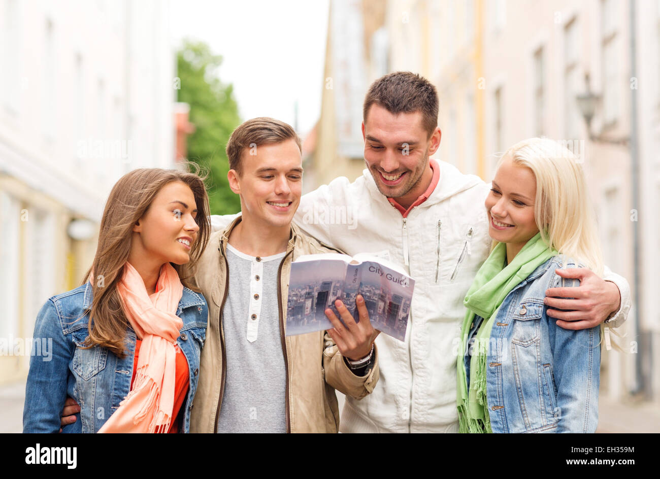 group of friends with city guide exploring town Stock Photo - Alamy