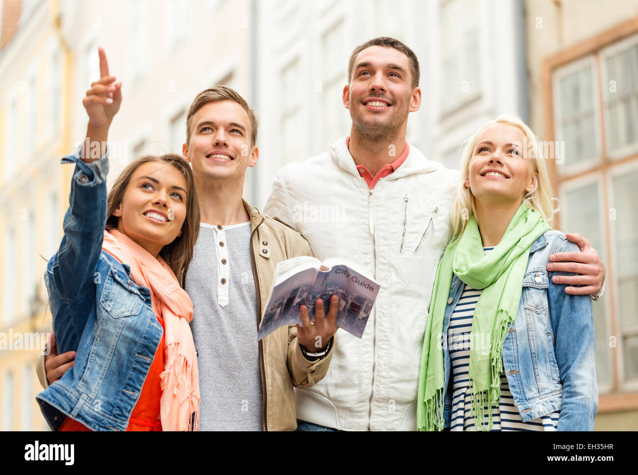 group of friends with city guide exploring town Stock Photo - Alamy