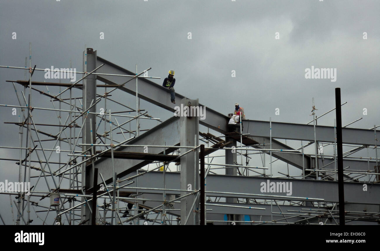 Filipino men work on top of a building under construction along EDSA ...