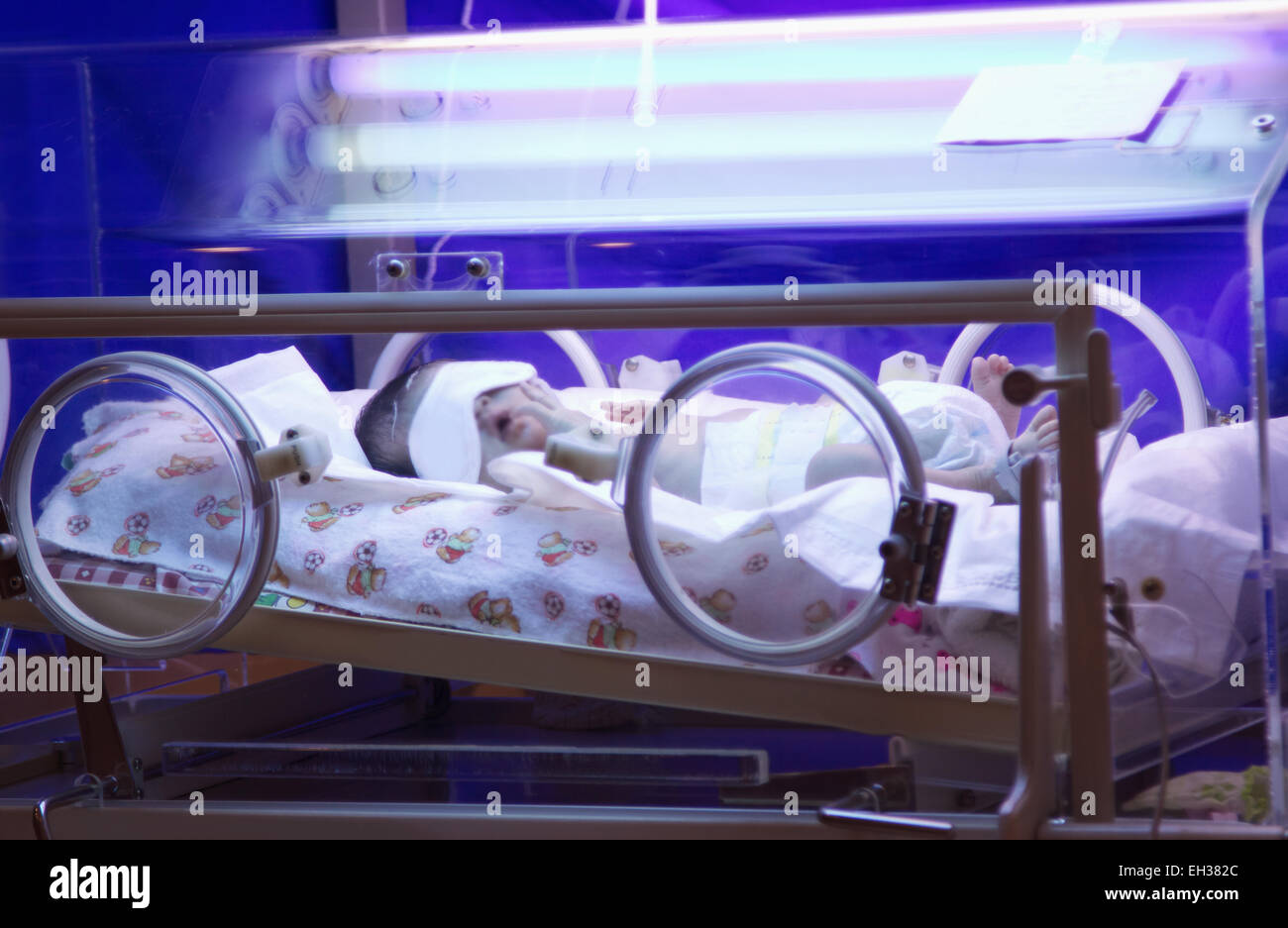 Newborn premature in incubator under blue UV light Stock Photo - Alamy