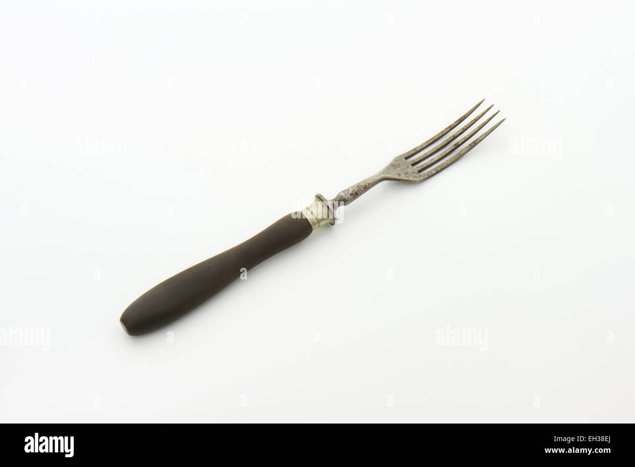 Old silver fork with black handle on white background Stock Photo - Alamy