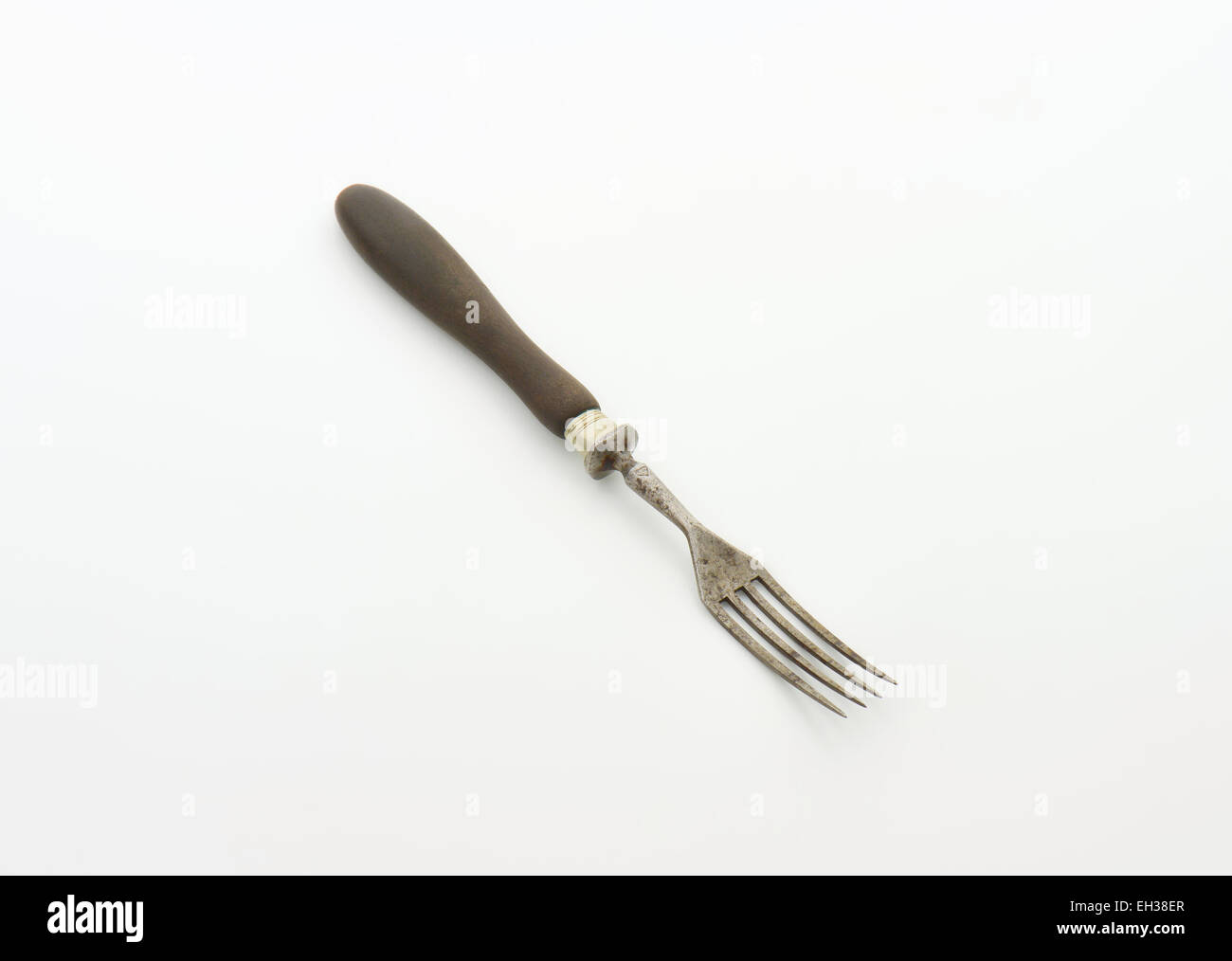 Old silver fork with black handle on white background Stock Photo - Alamy