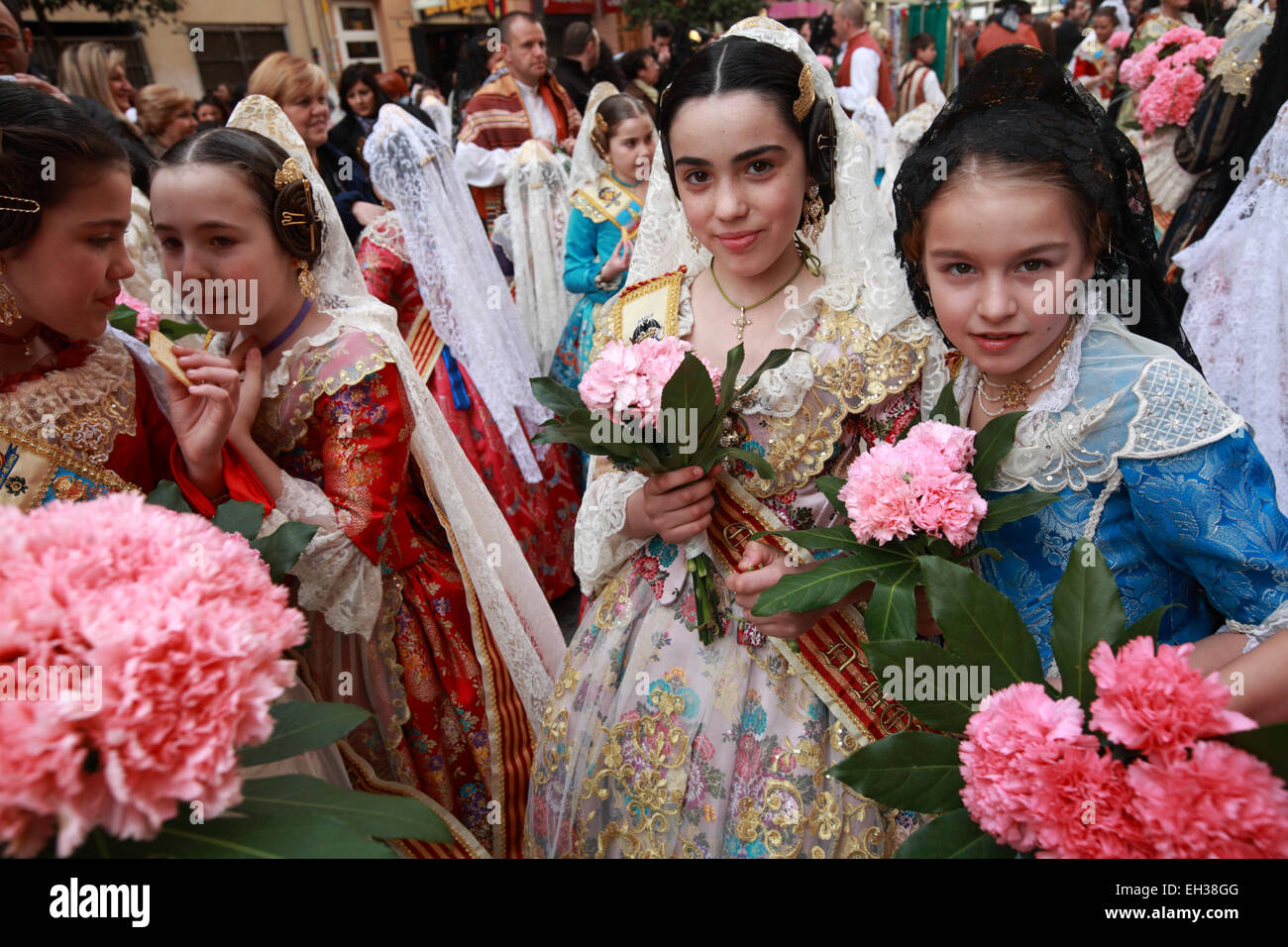 local girls in traditional Las Fallas festival costumes holding flowers ...