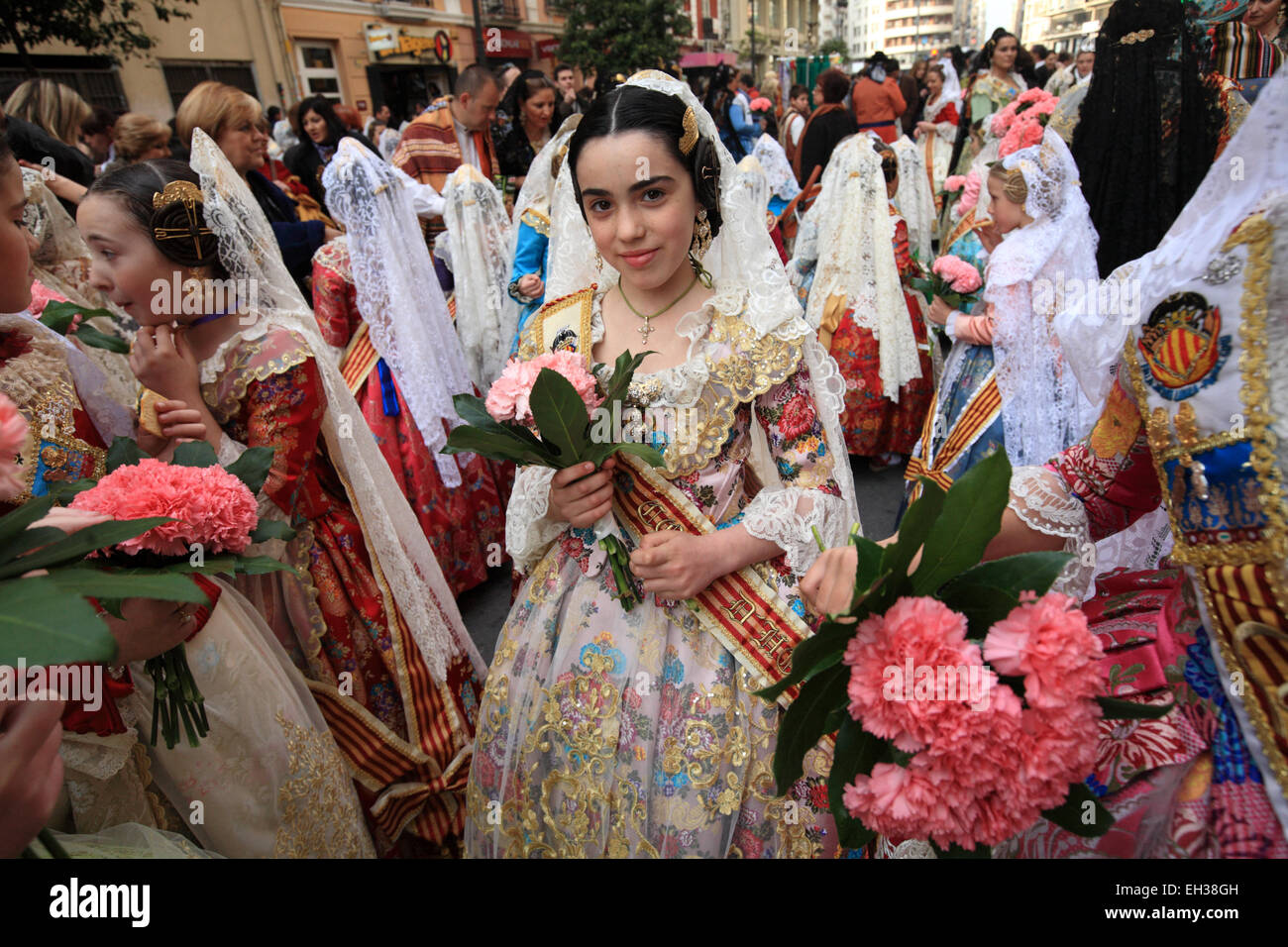 A local girl in traditional Las Fallas festival costumes holding ...