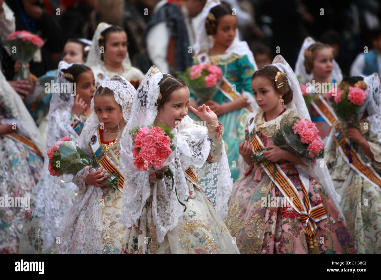 Local girls in traditional Las Fallas festival costumes holding flowers ...