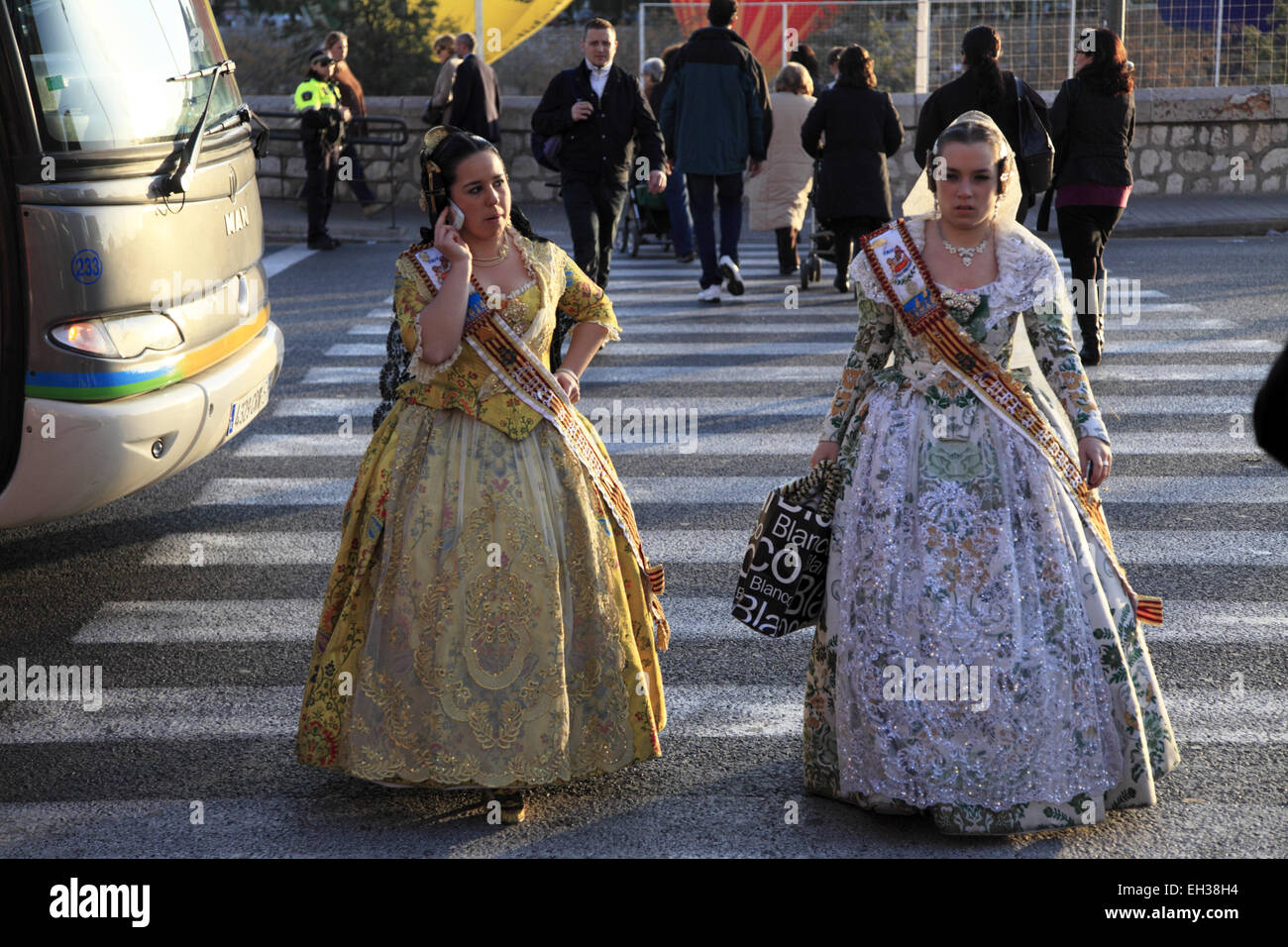 Two woman in traditional Fallas costumes walking on street crossing ...