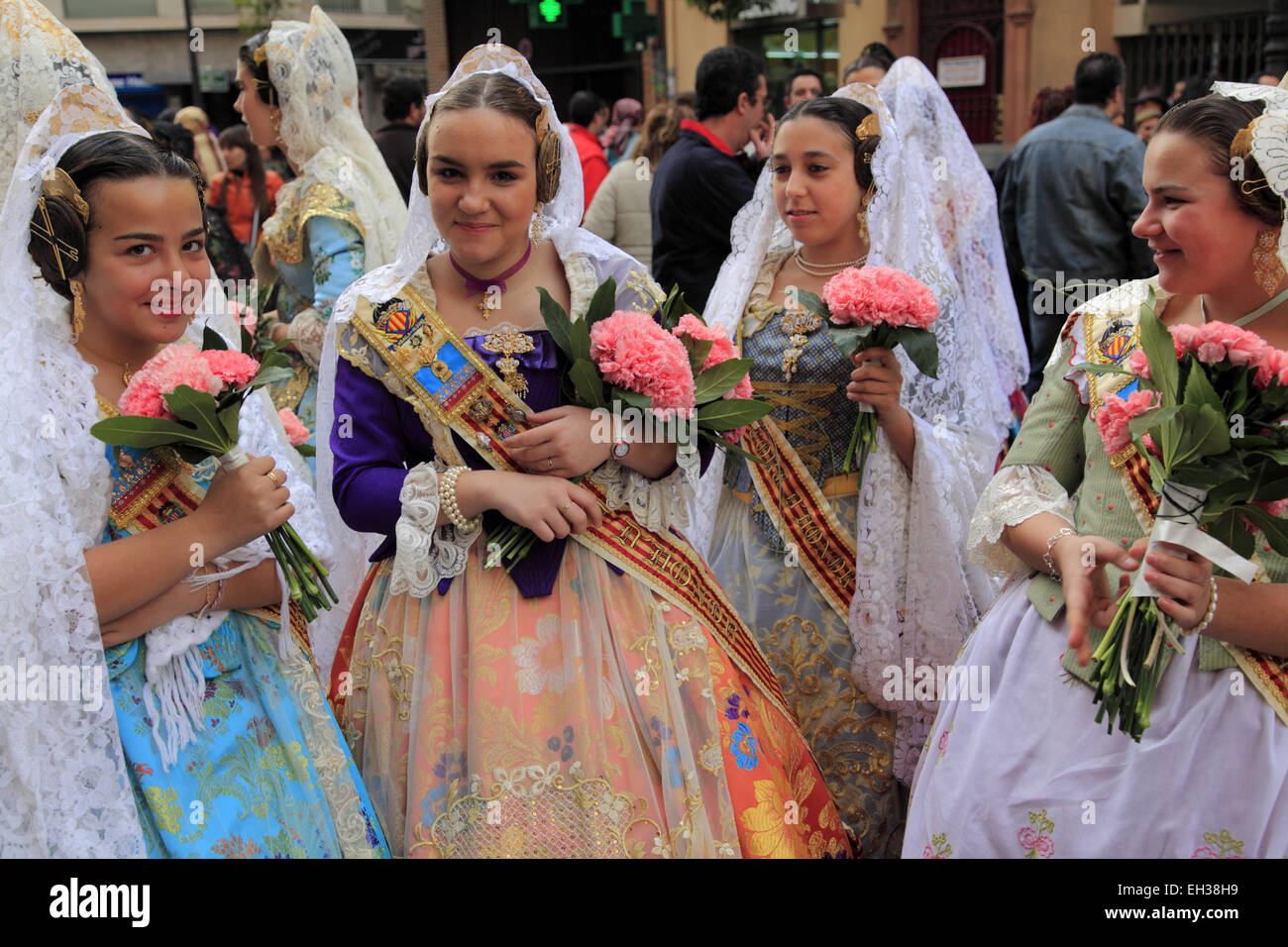 local girls in traditional Las Fallas festival costumes holding flowers ...