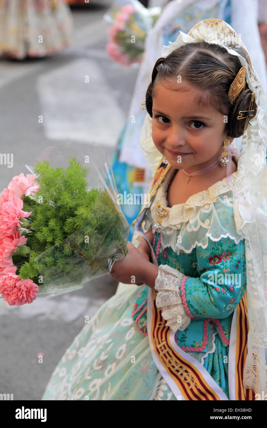 A young girls in traditional Las Fallas festival costumes holding ...