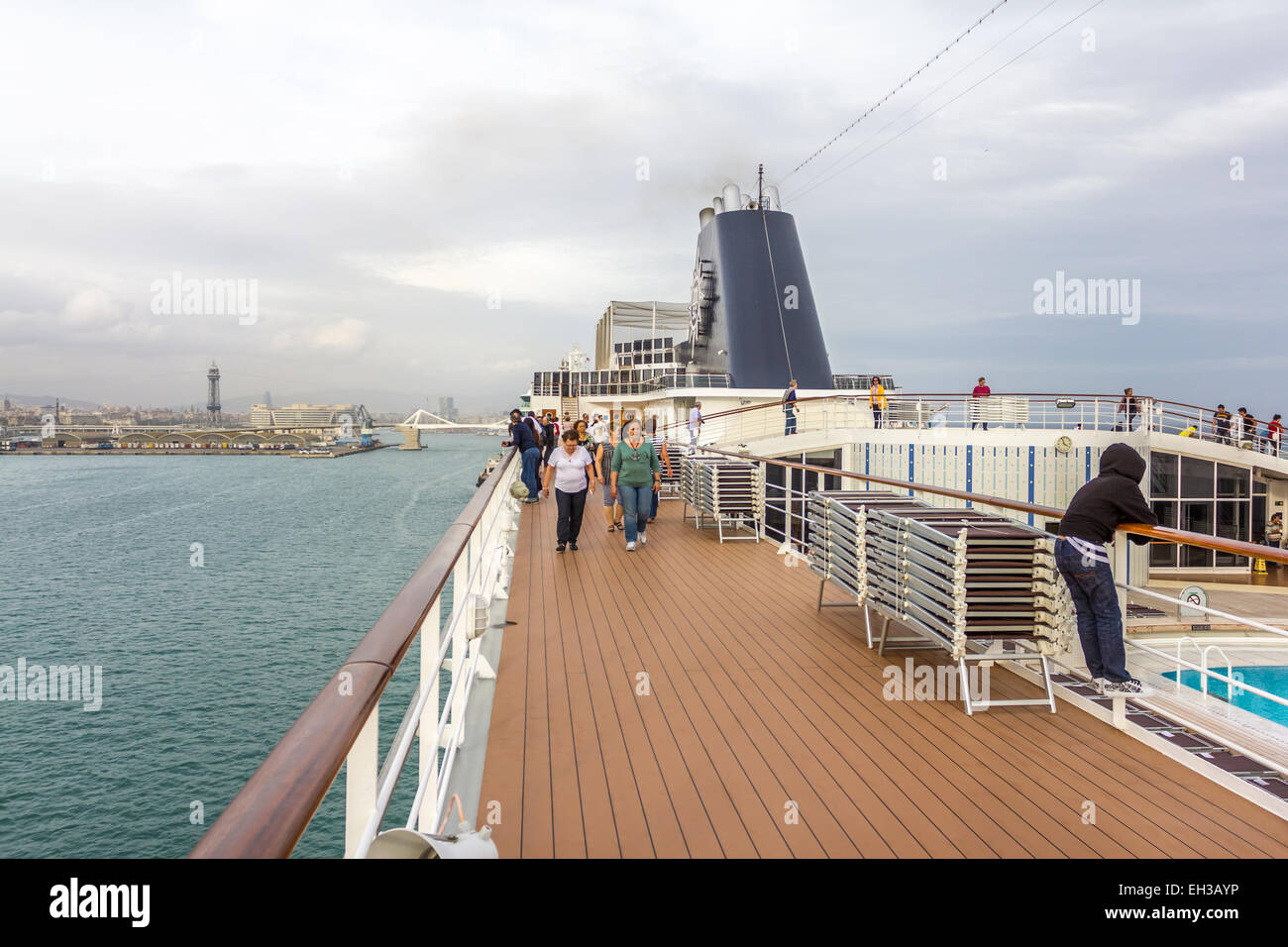 Passengers on cruise ship deck departing Port of Barcelona Harbour ...