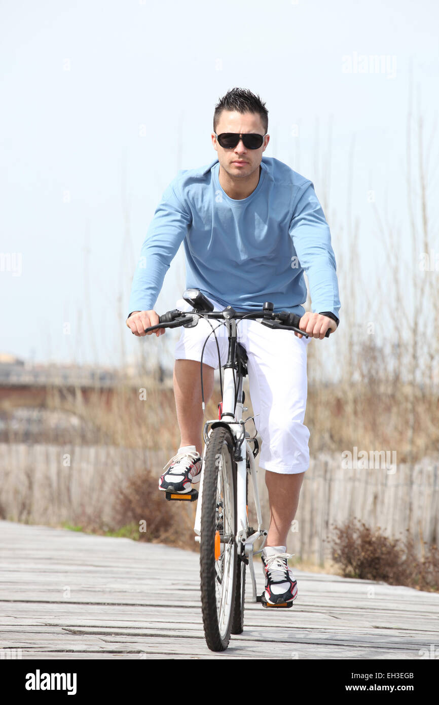 Young man riding a bicycle Stock Photo - Alamy