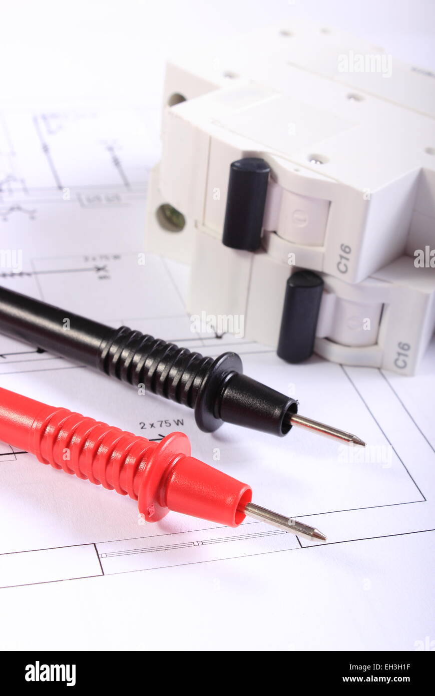 Cables of multimeter and electric fuse lying on construction drawings ...
