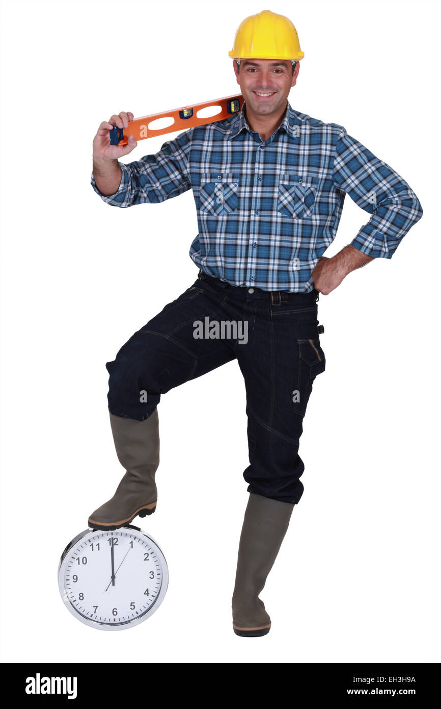 Builder with a spirit level and a clock Stock Photo - Alamy