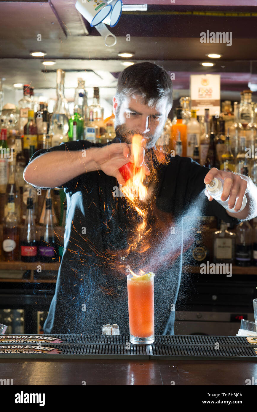 A male barman, bar tender, mixologist makes a fantastic cocktail in a ...