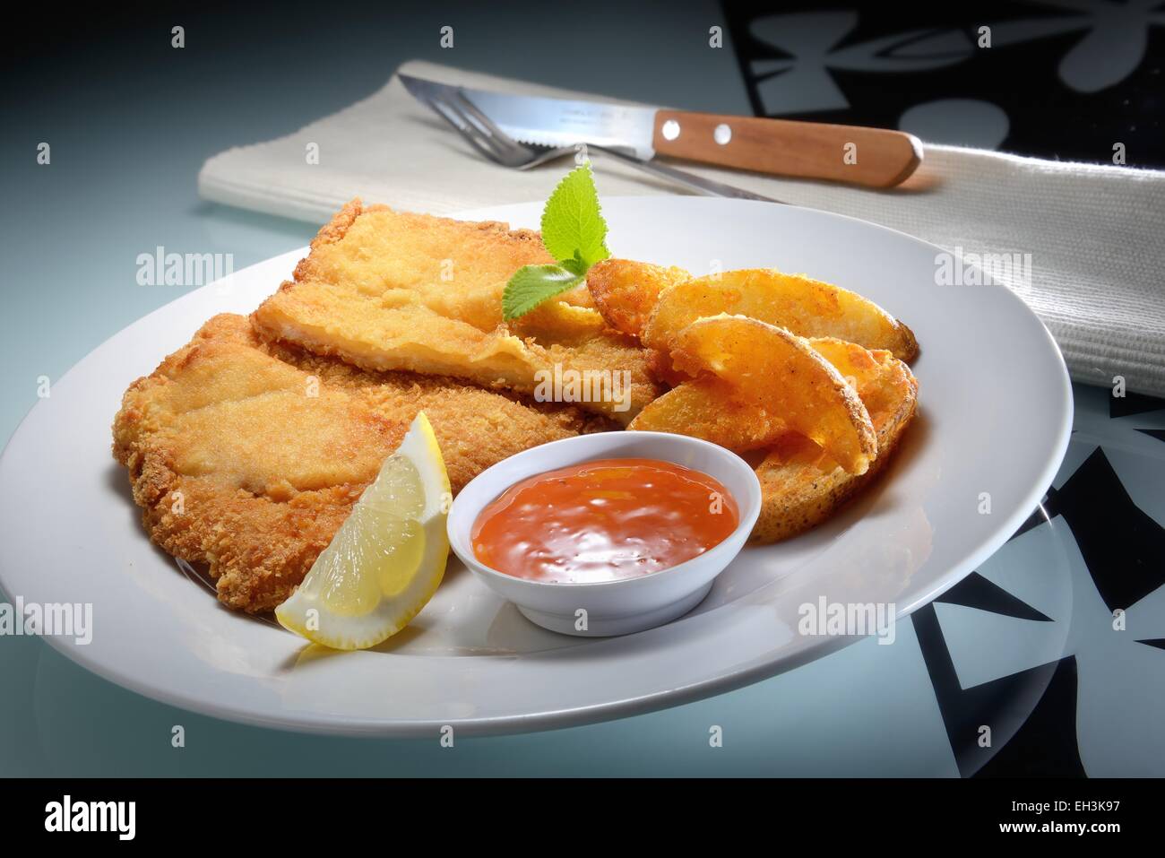 Fried fillet fish with nice table setting Stock Photo - Alamy