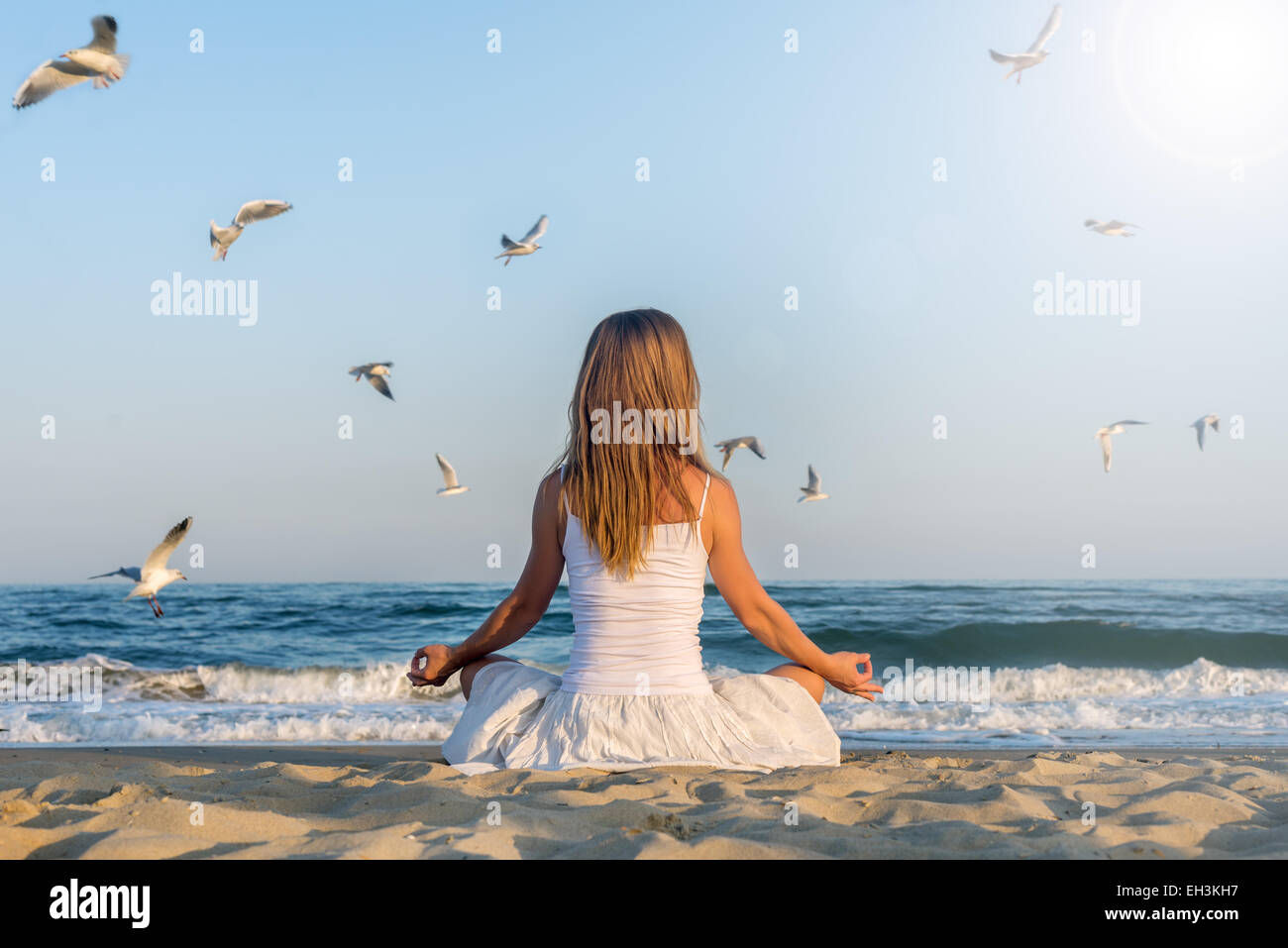 Woman meditating at the sea Stock Photo - Alamy