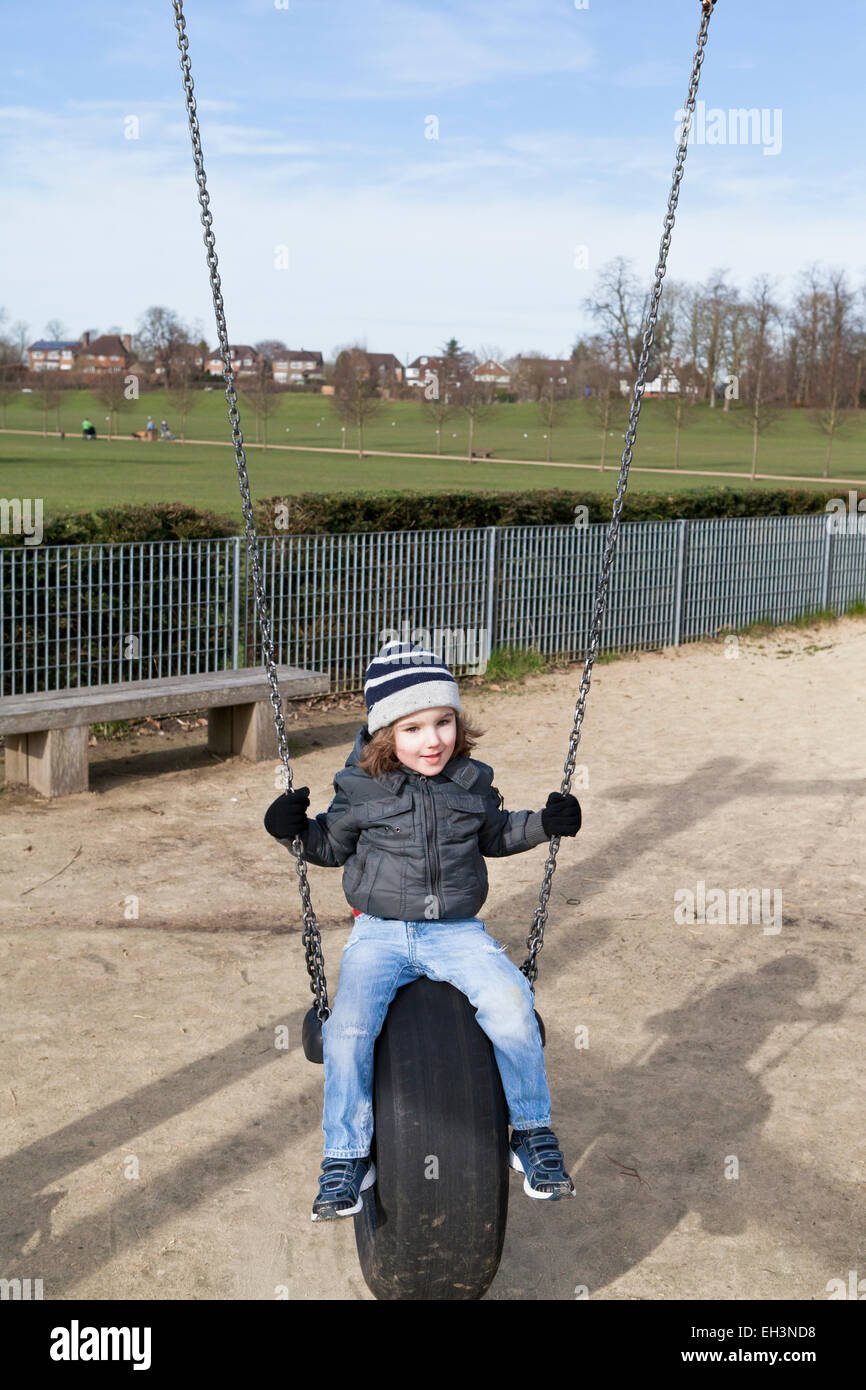 Toddler on a swing in a playground Stock Photo - Alamy