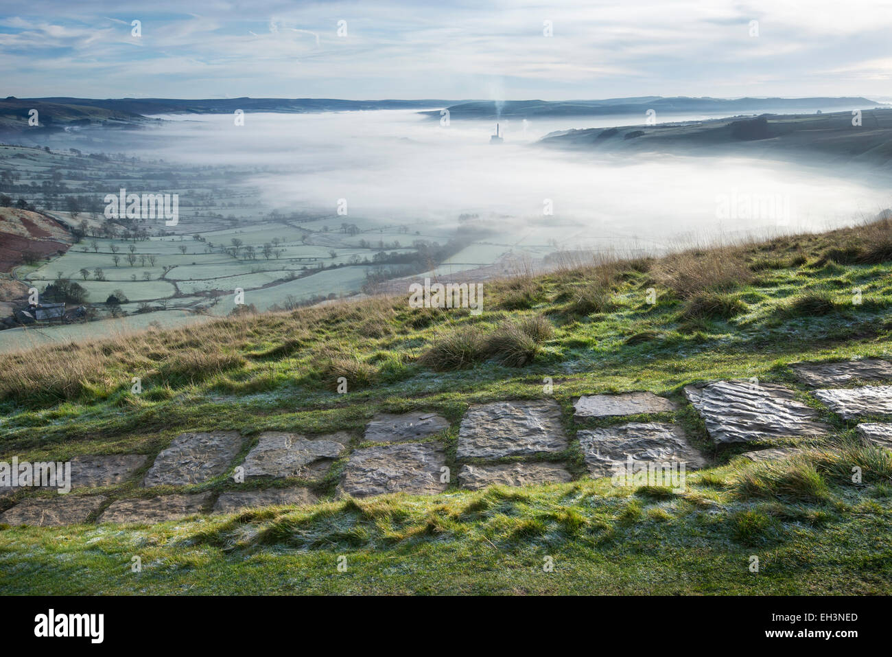Paved path on Mam Tor with view over mist at Castleton in the Peak ...