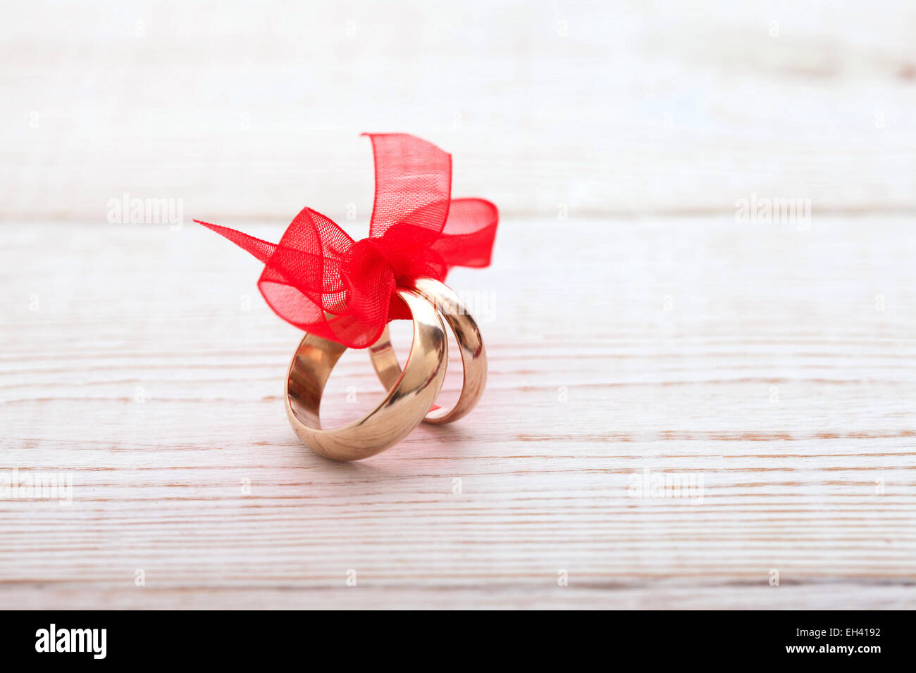 Gold wedding rings red ribbon hi-res stock photography and images - Alamy
