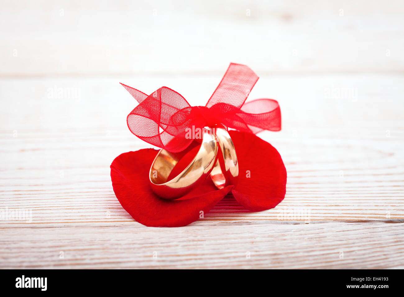 Gold wedding rings red ribbon hi-res stock photography and images - Alamy