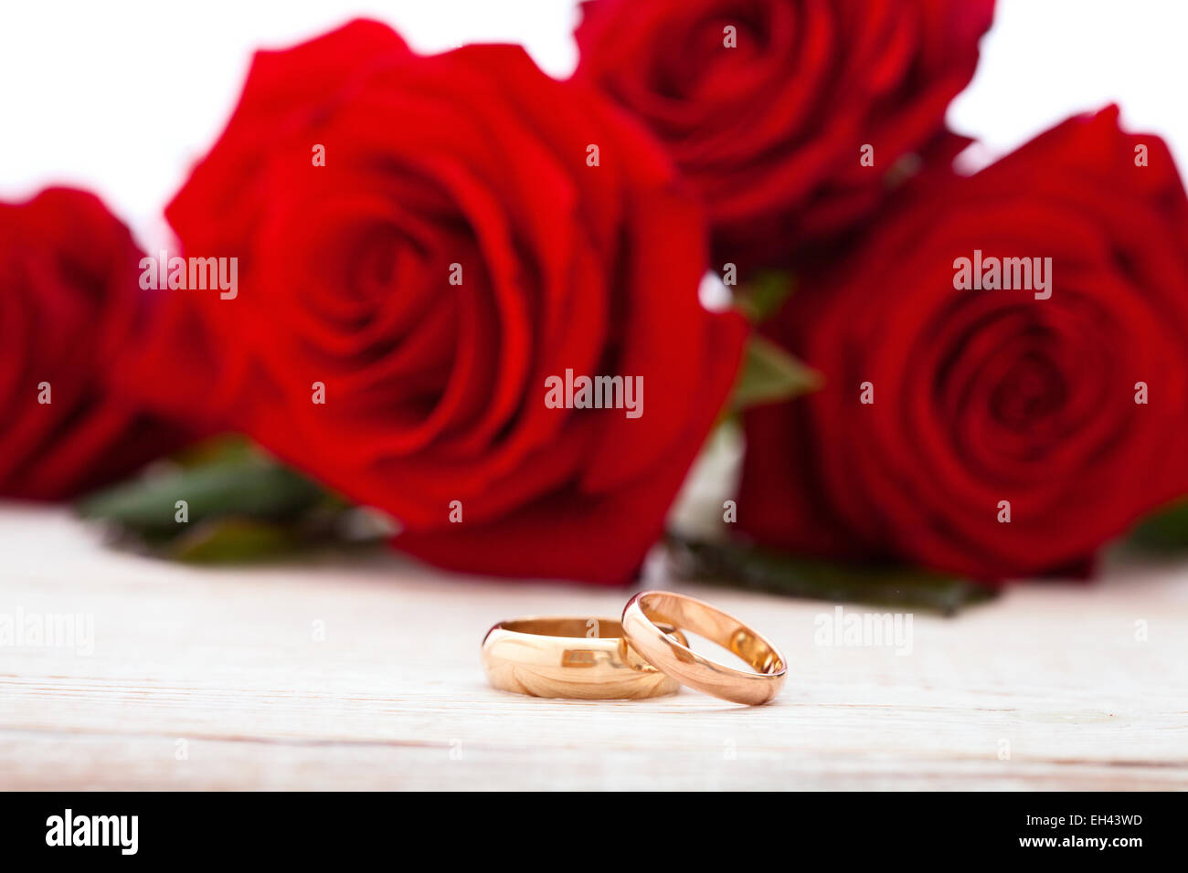 Wedding rings and wedding bouquet of red roses Stock Photo - Alamy
