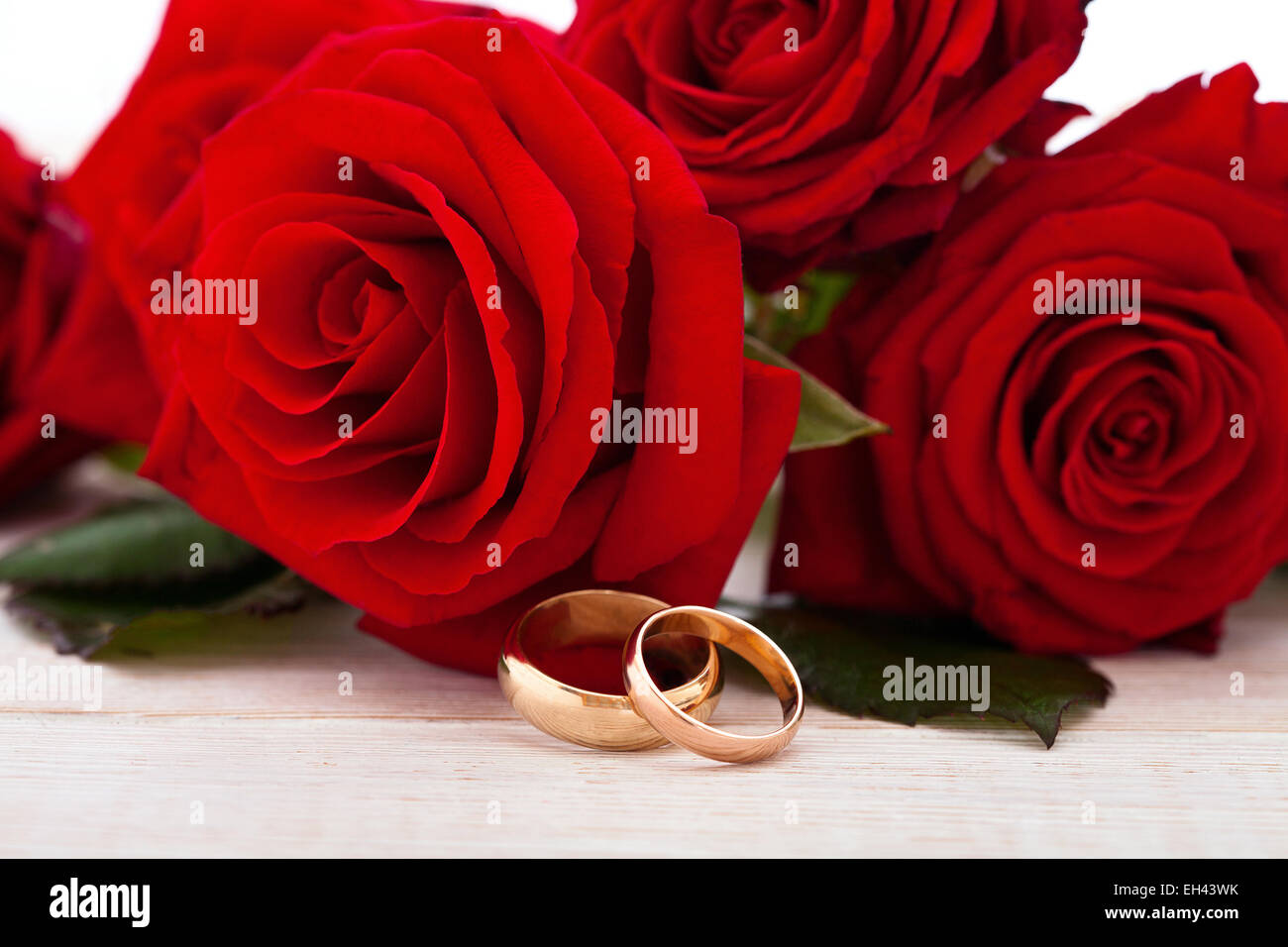 Wedding rings and wedding bouquet of red roses Stock Photo - Alamy