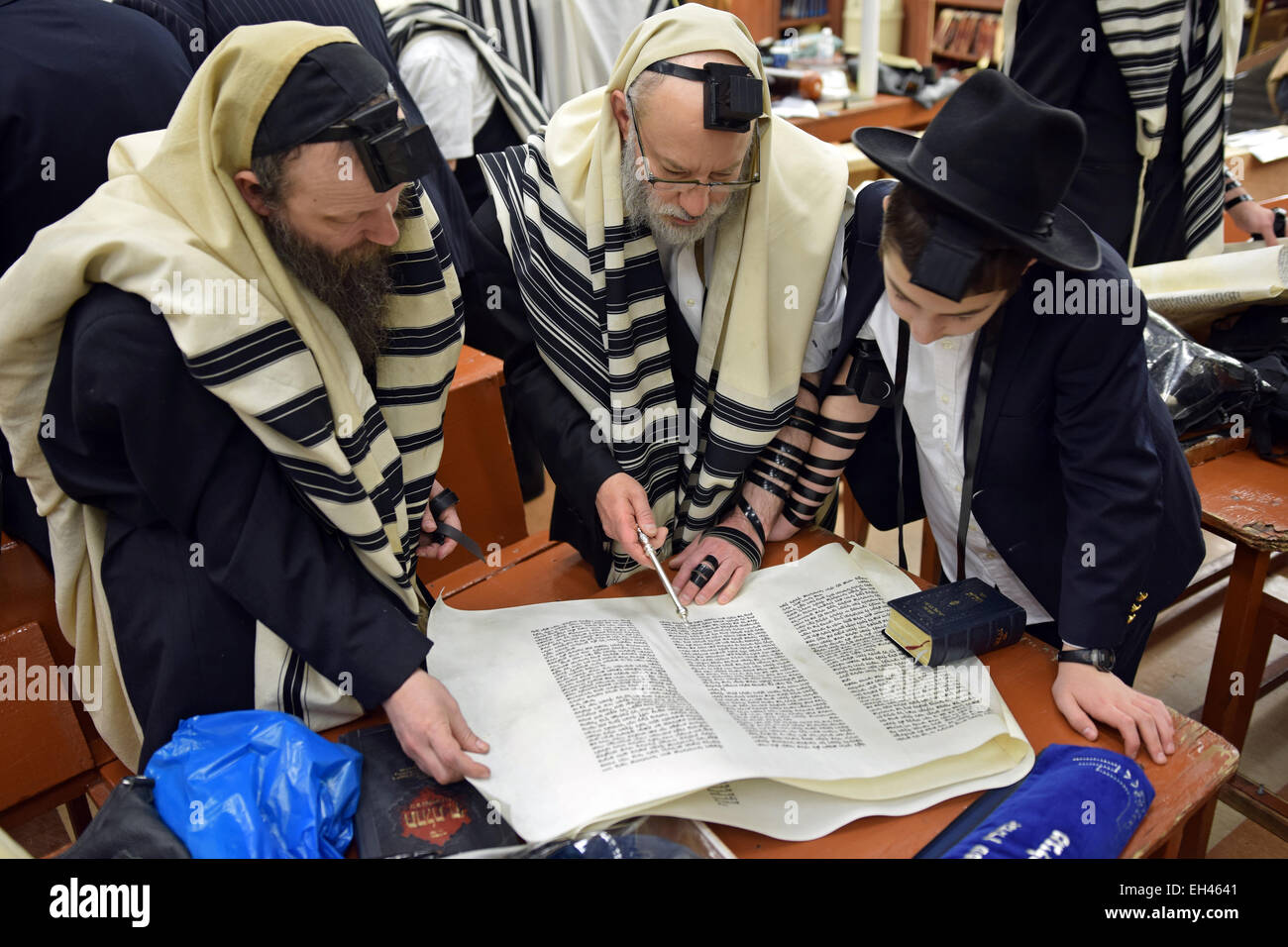 Religious Jewish men reading from the Megillah during Purim services in ...