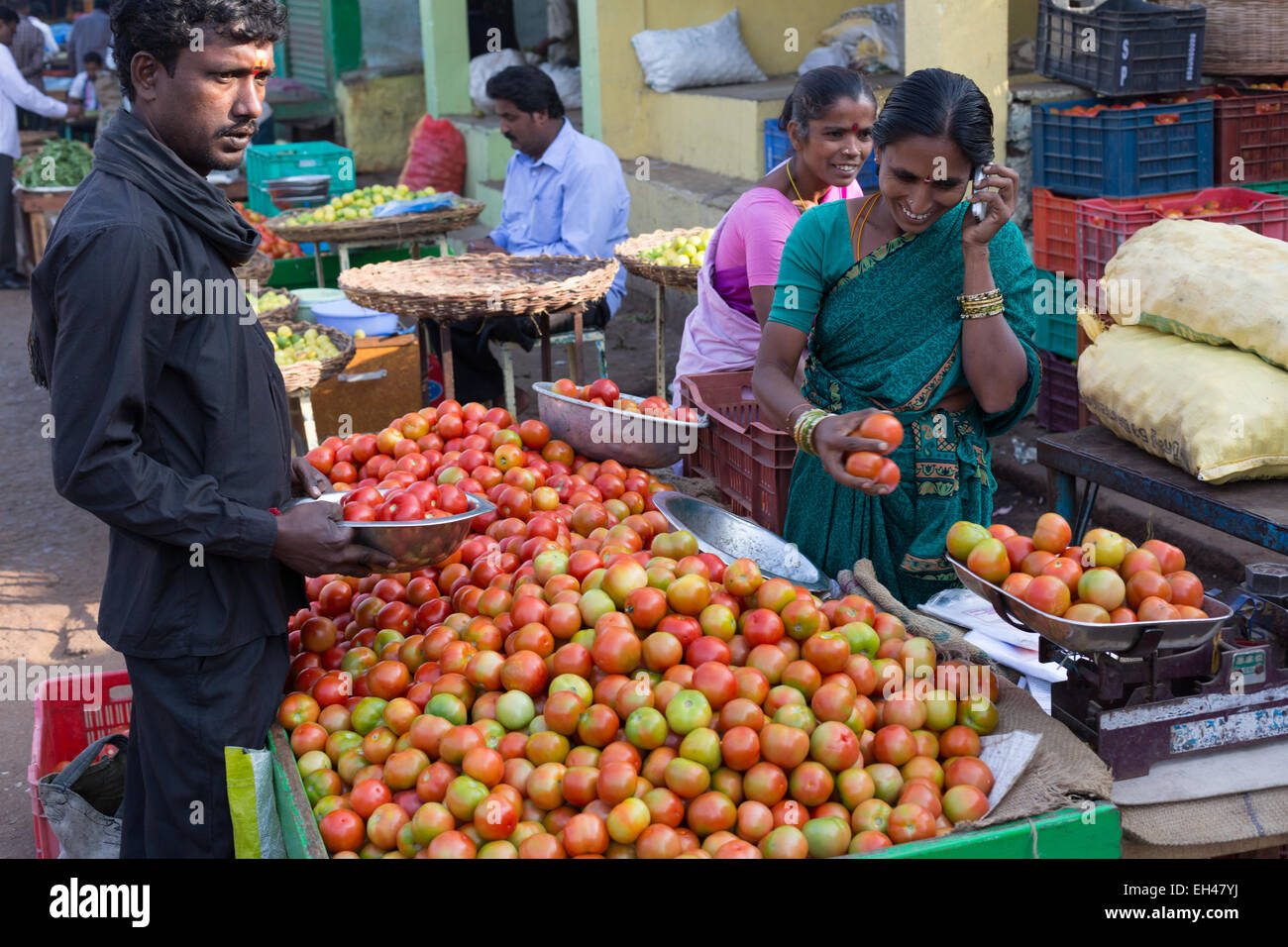 A woman vegetable vendor with mobile phone at a vegetable market Stock ...